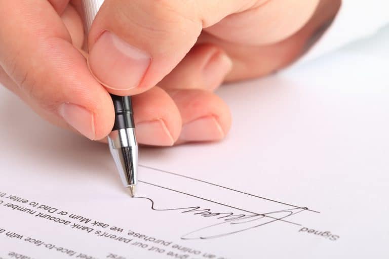 Detail Of A Male Hand Signing A Contract - Belson Asphalt Paving | Michigan